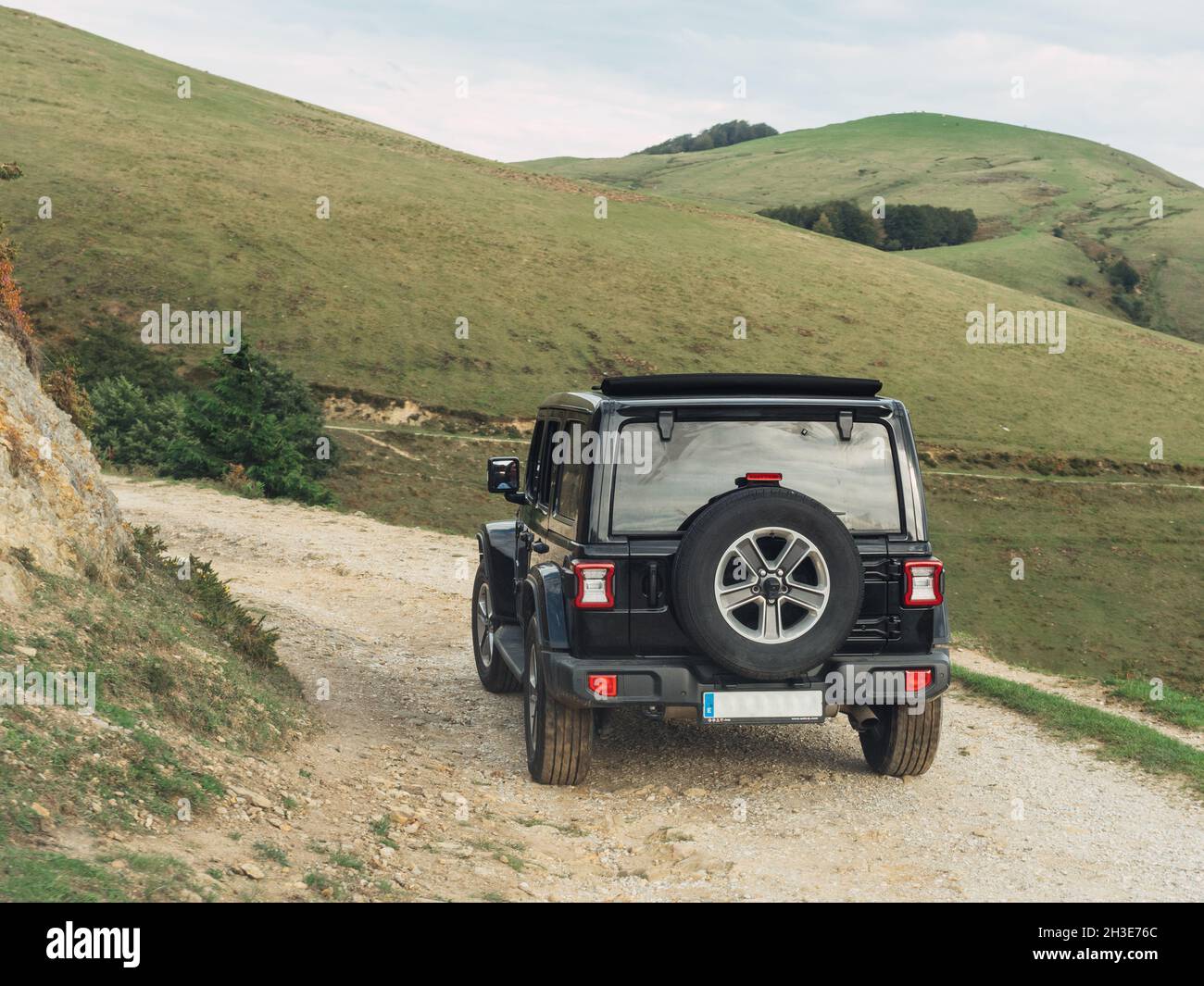 Back view of SUV car driving along rough road during trip in ...