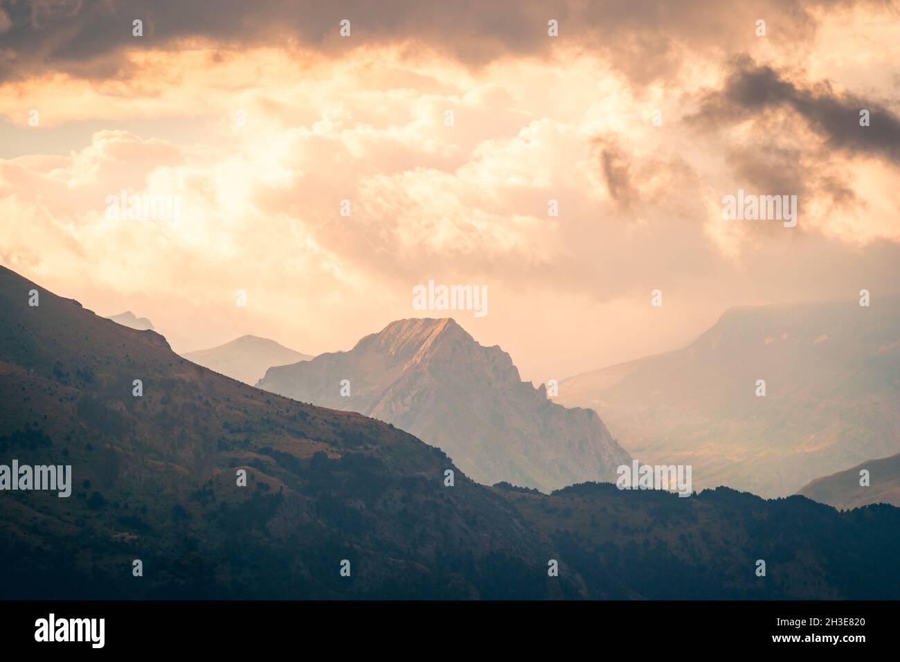 Tall mountain range of Pyrenees in highlands under majestic clouds in ...