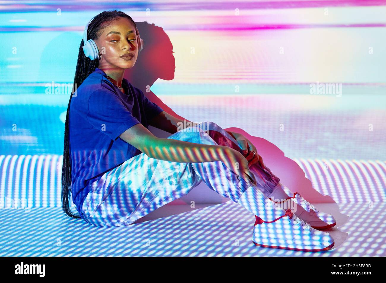 Delighted African American female in flower necklace wearing bright ...