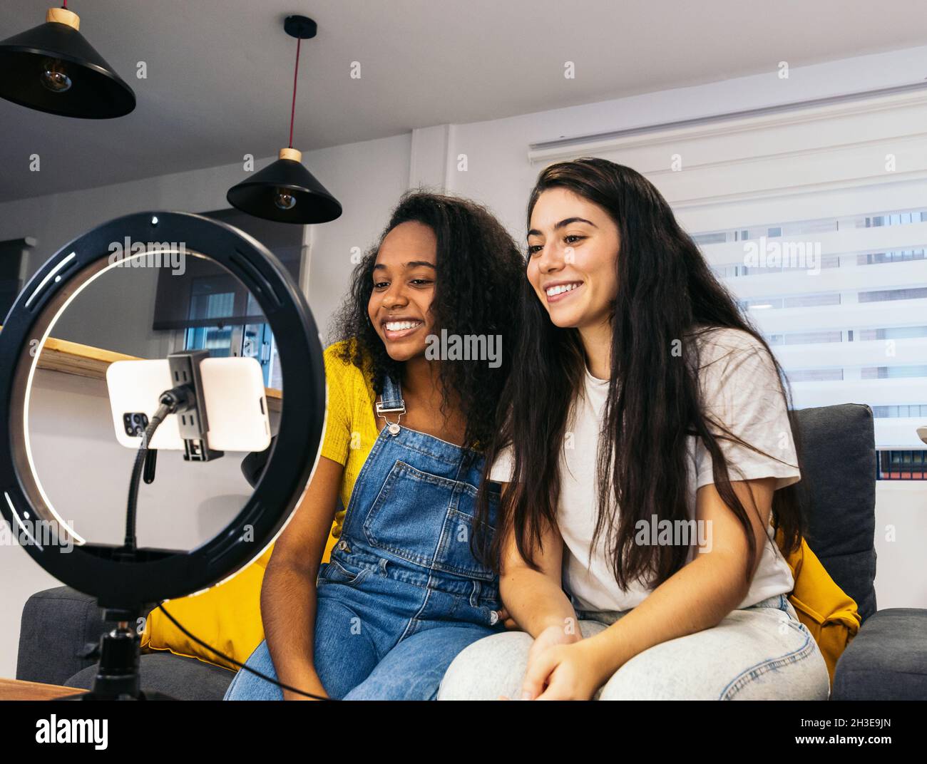 Positive female with long dark hair in casual clothes sitting and ...