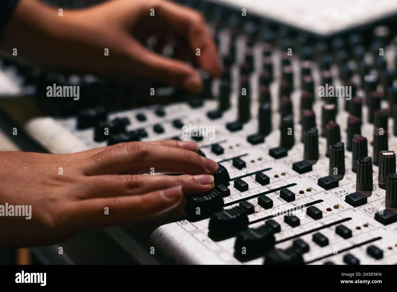 Crop anonymous person using switches and buttons on professional sound ...