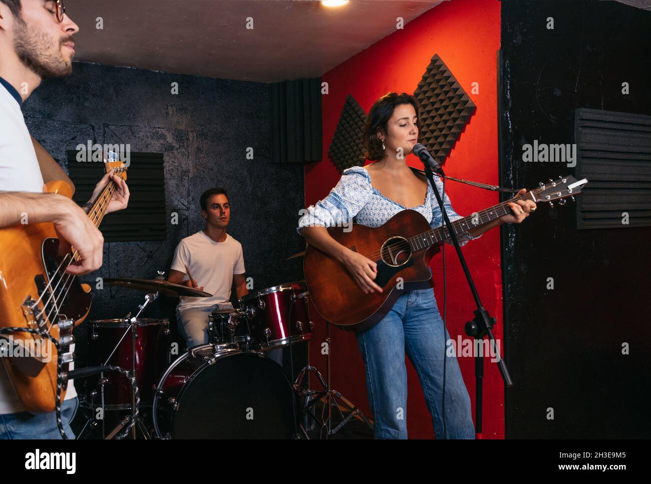 Group of people in casual clothes playing guitars and drums while Woman ...