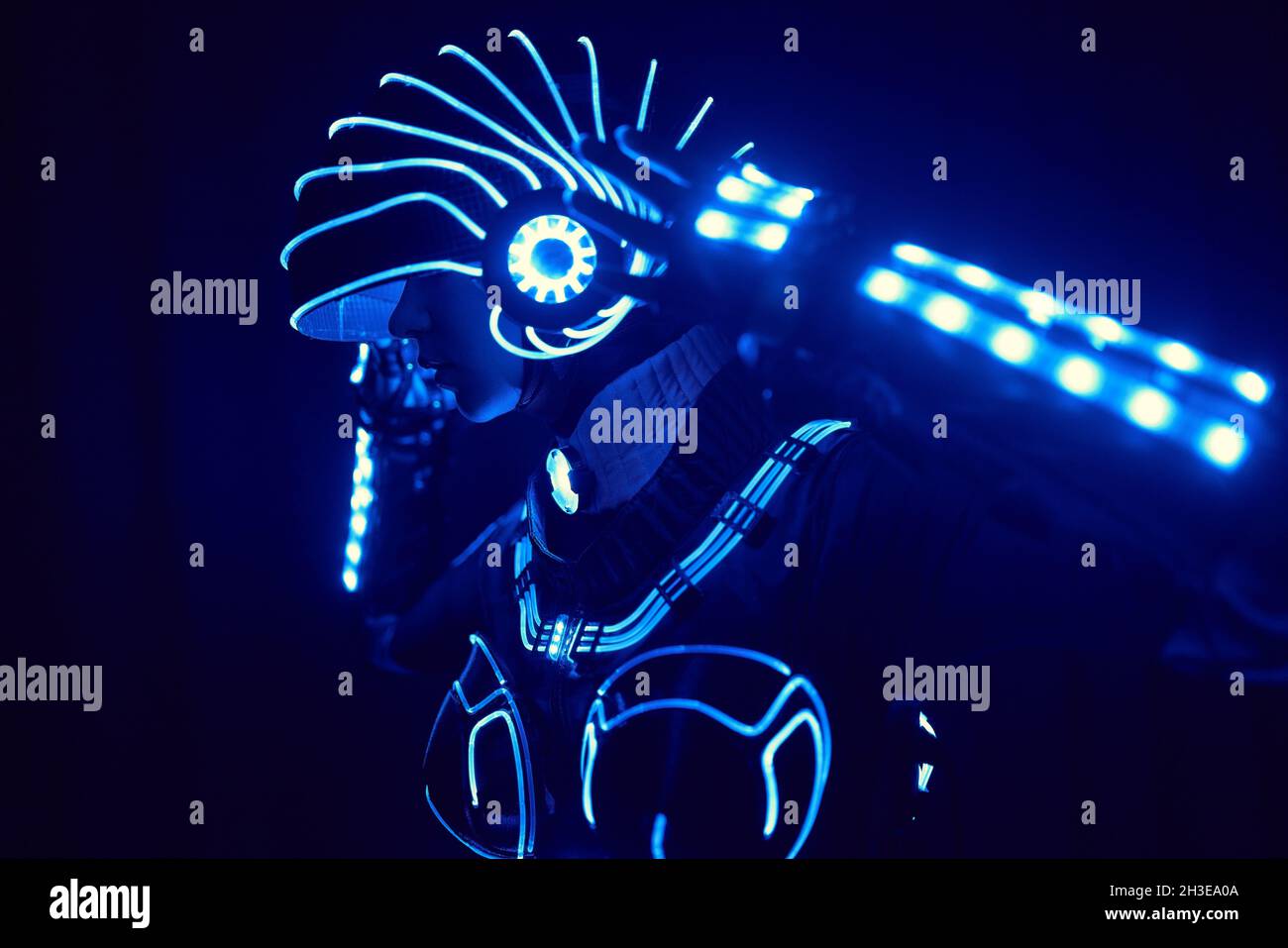 Faceless person in contemporary glowing suit of space cyborg with neon ...