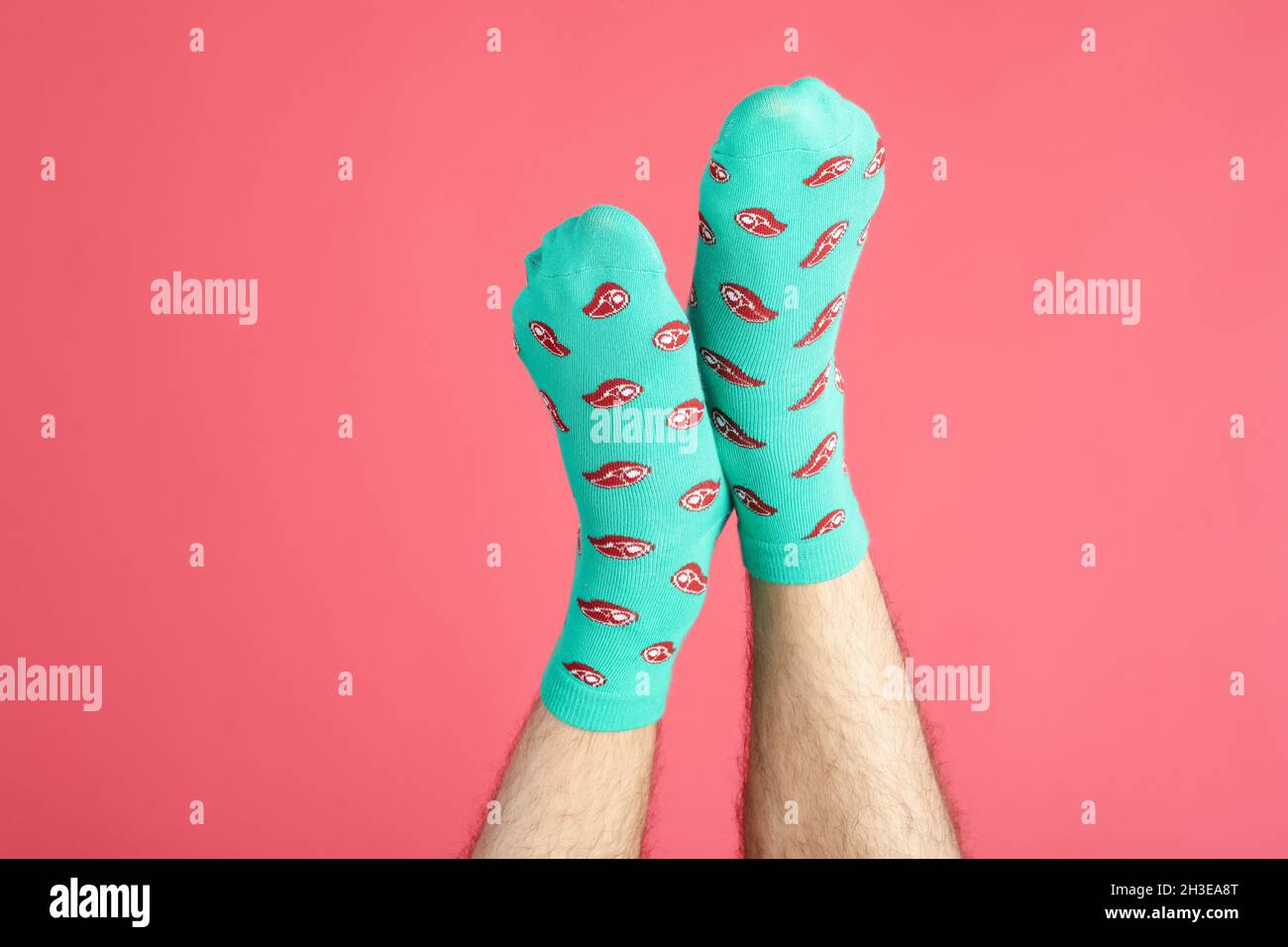 Male legs in socks with meat slices on pink background Stock Photo - Alamy