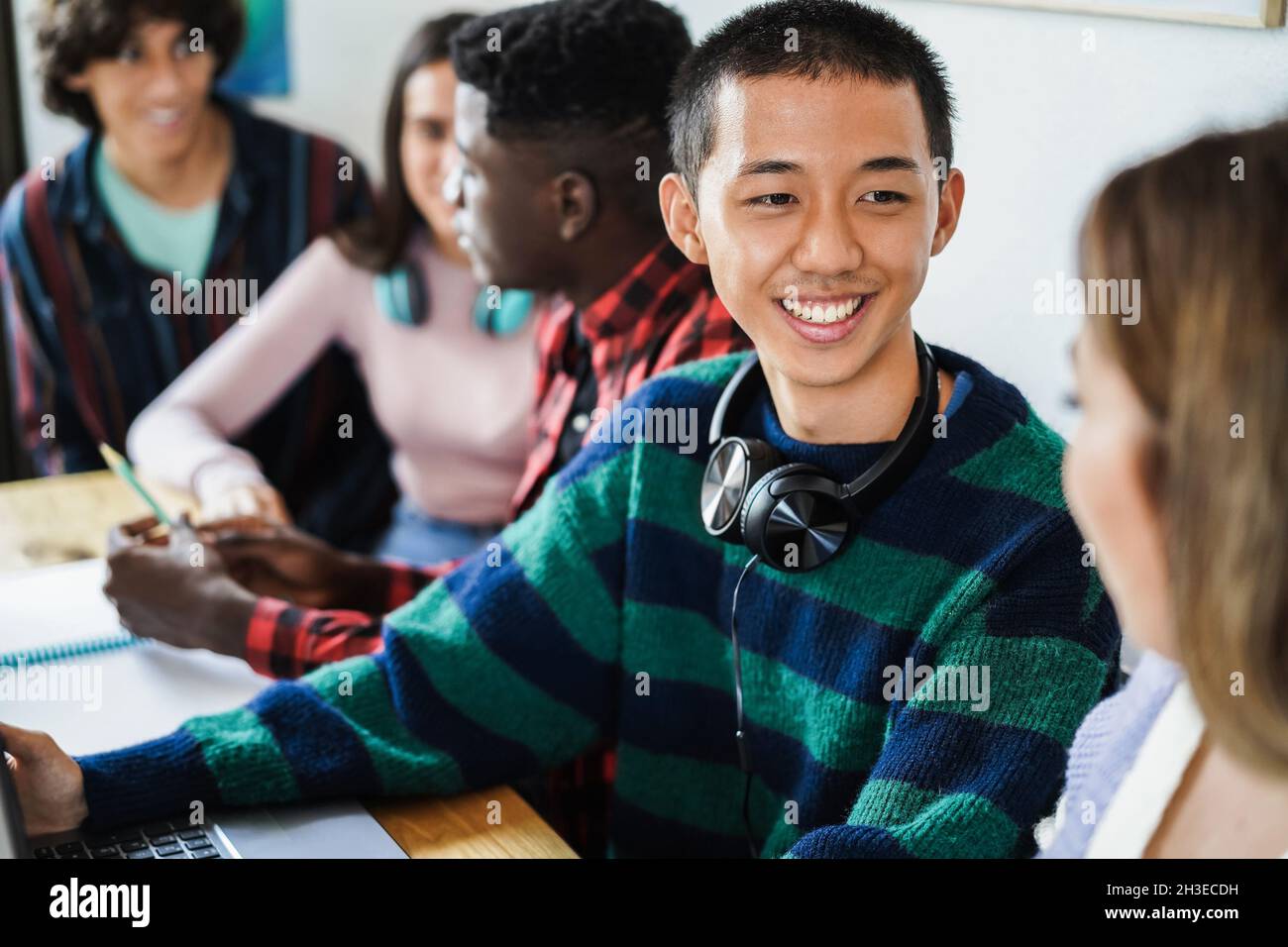 Multiracial students studying together at library - Focus on asian boy ...