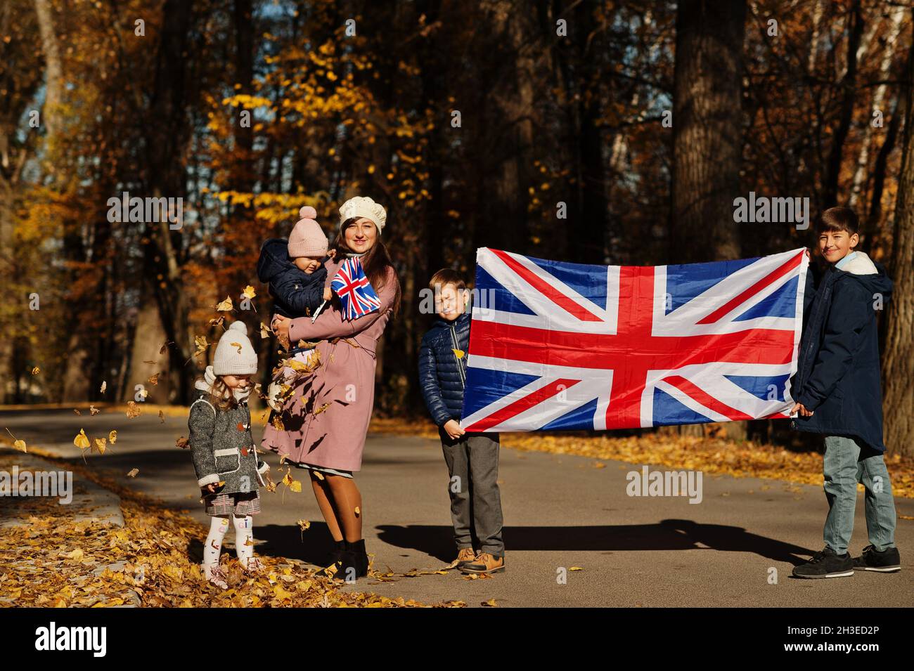 National holiday of United Kingdom. Family with british flags in autumn ...