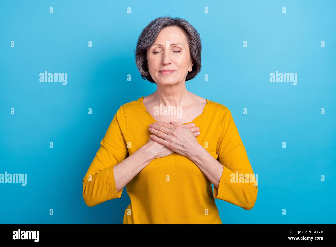 Portrait of attractive peaceful woman touching heart sincere feelings ...