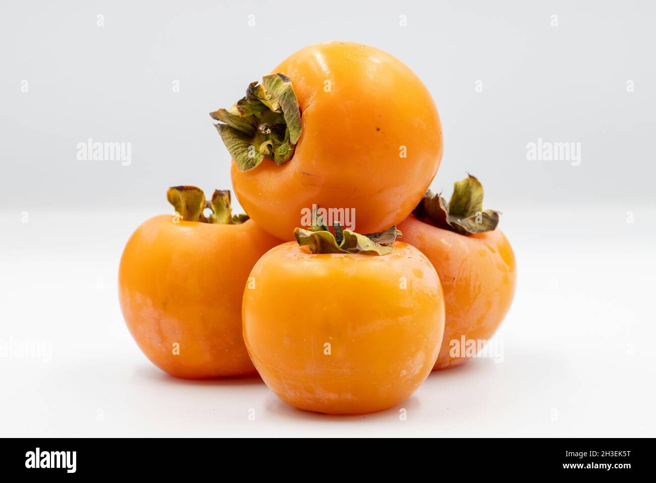 Fresh organic ripe persimmons fruits on a white background with shadow ...