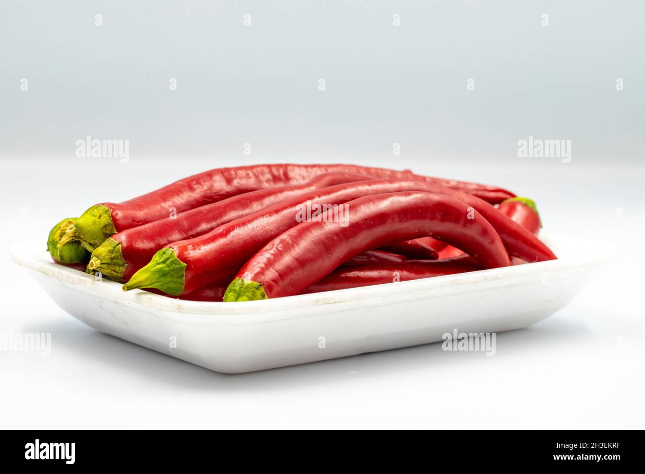 Packet red hot chili pepper on white background with shadow. close up ...