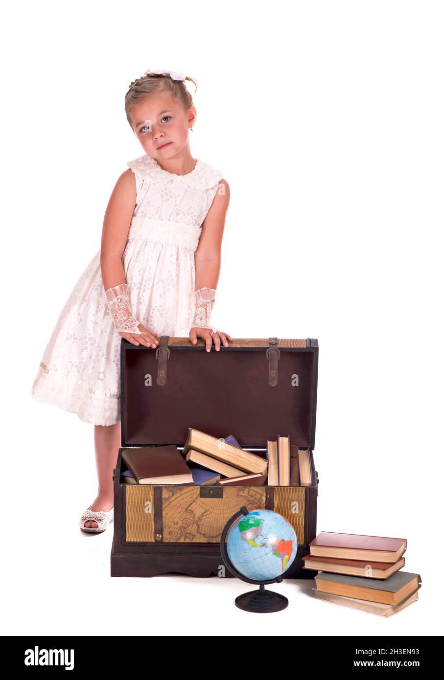 girl and a chest with books. little girl looking inside a trunk with ...