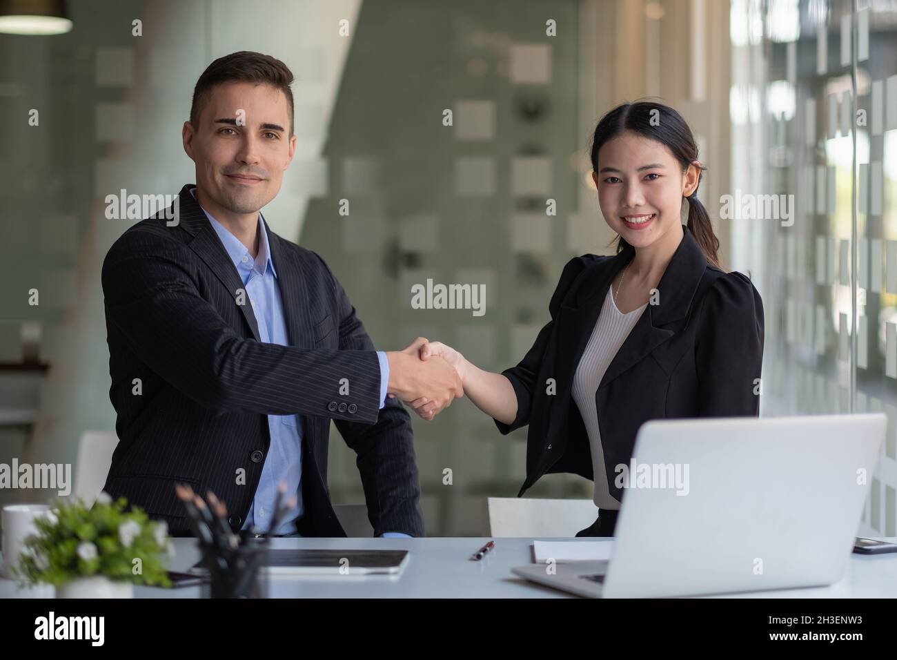 Happy caucasia male and asian female hand shaking, successful ...