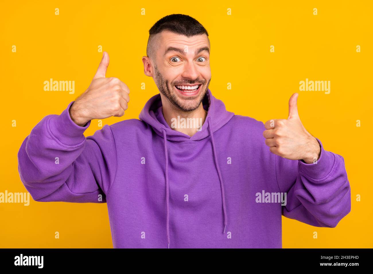 Photo of cool millennial brunet guy show thumb up wear violet hoodie ...