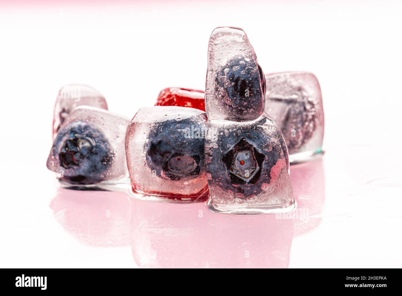 Fresh berries frozen in ice cubes for drinks Stock Photo - Alamy