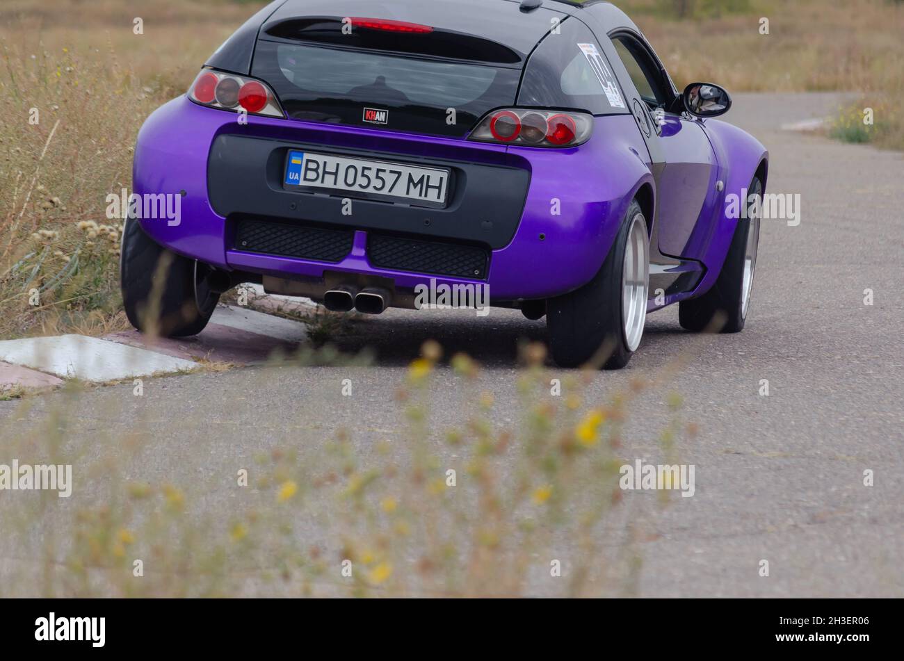 Rear views of the Little Lilac car driving on the road. The Smart ...