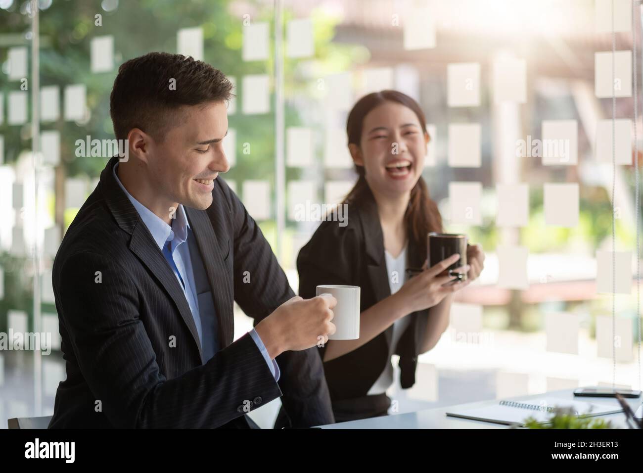 Friendly male leader laughing at group business meeting, happy young ...