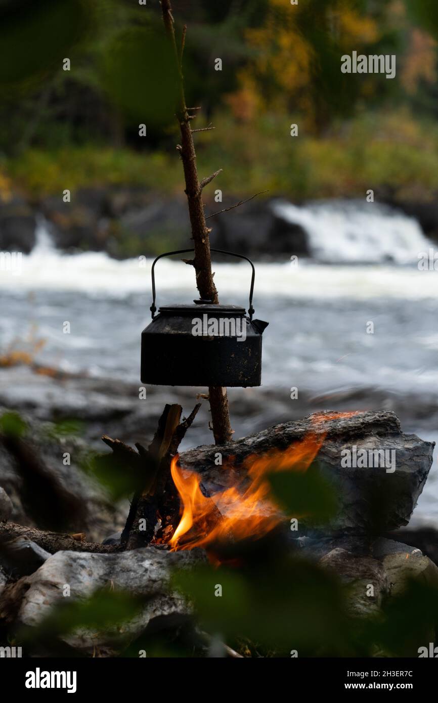 Vertical shot of a pot hanging over a fireplace - cooking at a camping ...