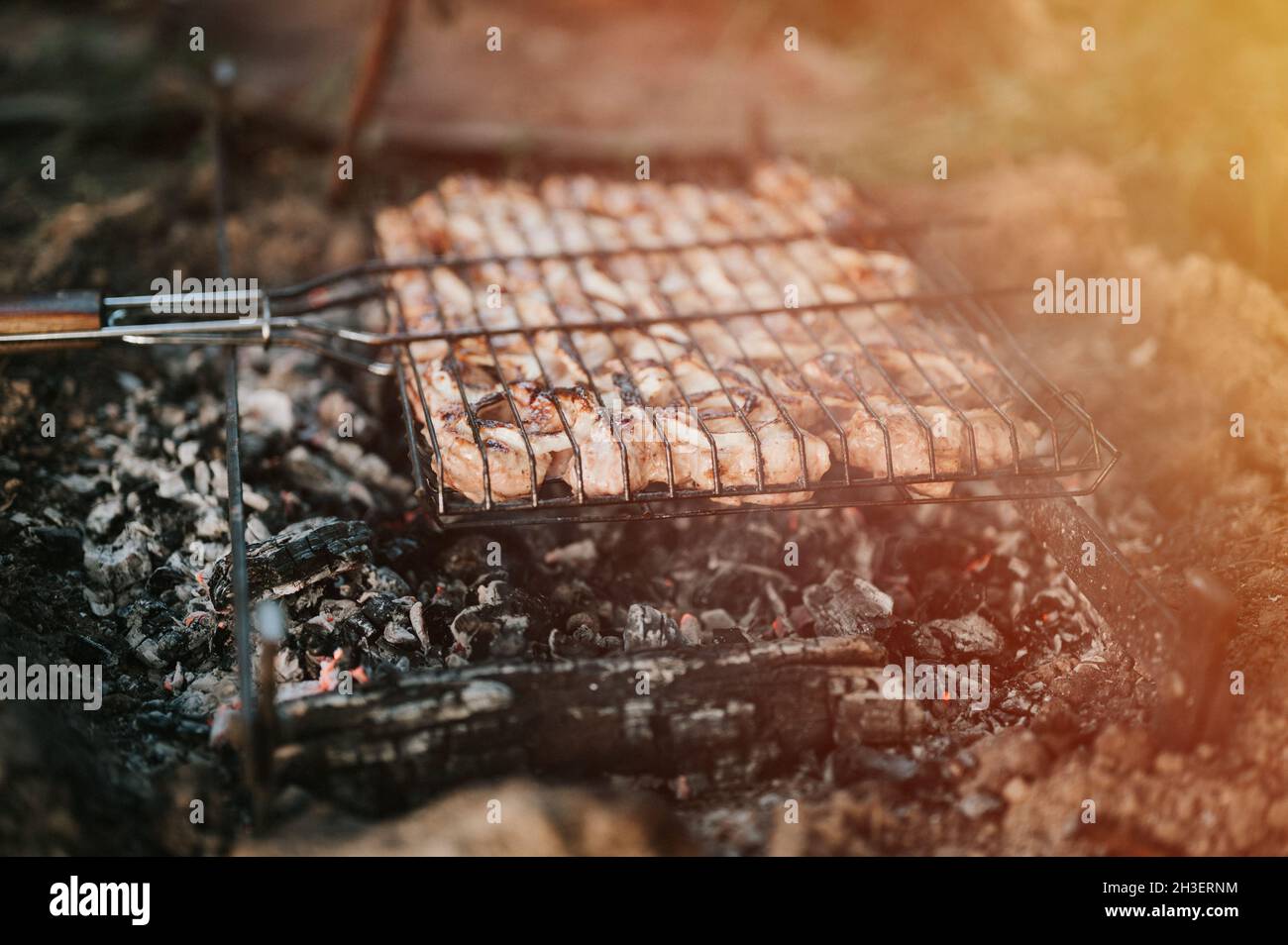 barbecue in camping conditions. pieces of pork meat with onions are ...