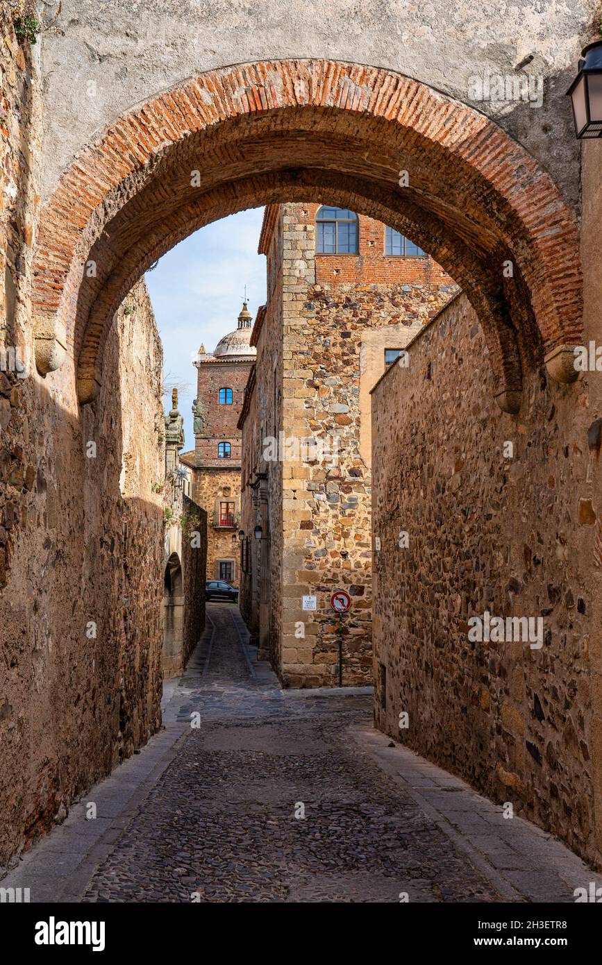 Narrow alley with old stone buildings at Caceres, Extremadura, Spain. A ...