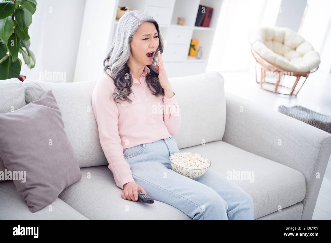 Portrait of attractive tired alone gray-haired woman sitting on divan ...