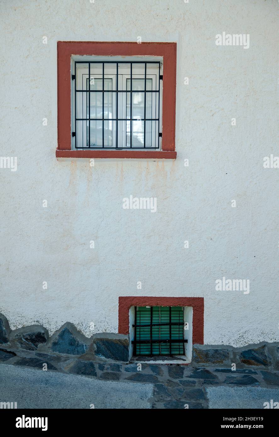 Two small windows with red frame on white wall Stock Photo - Alamy