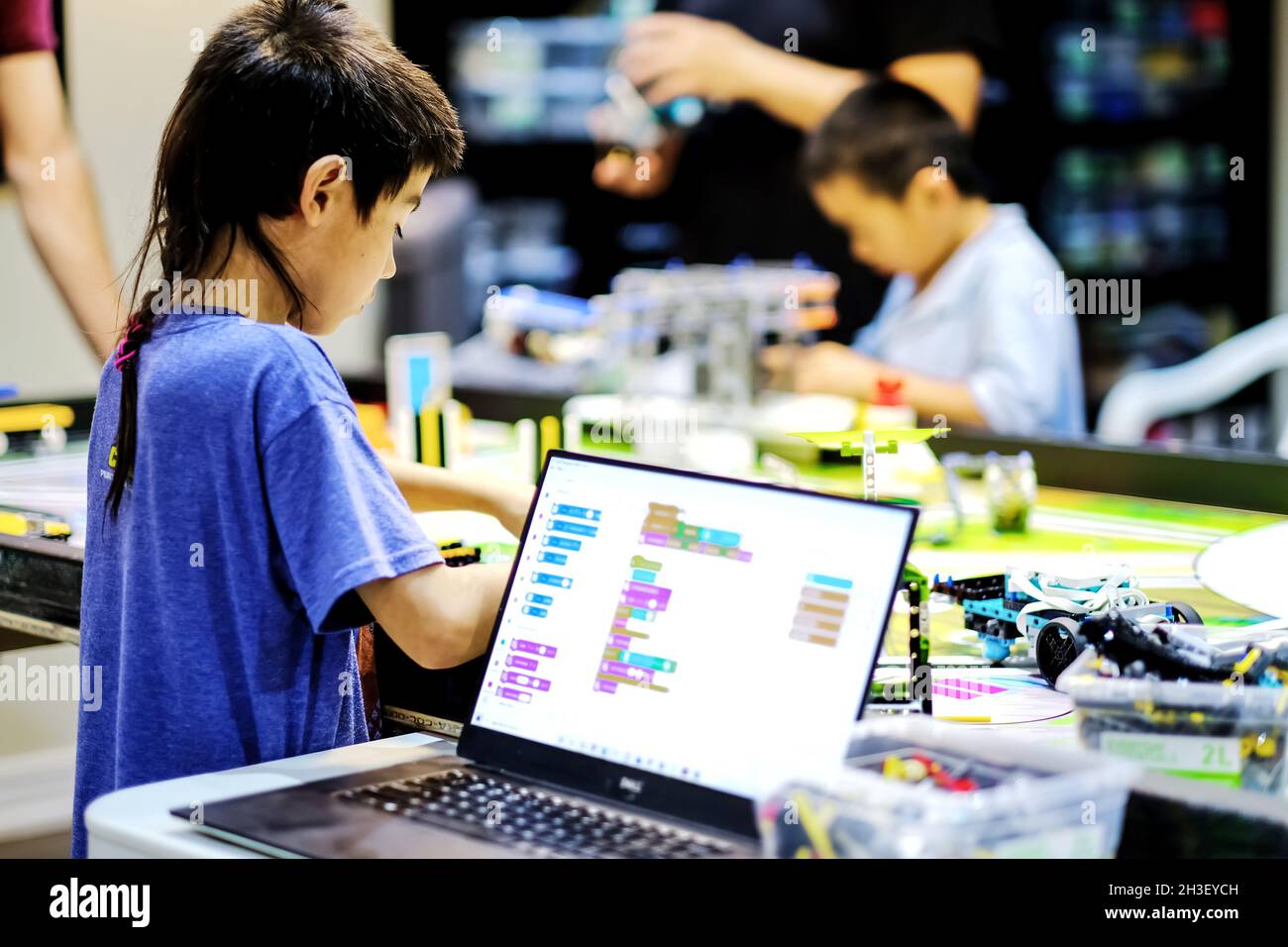 Group of kids attending Lego robotics class and building and testing ...