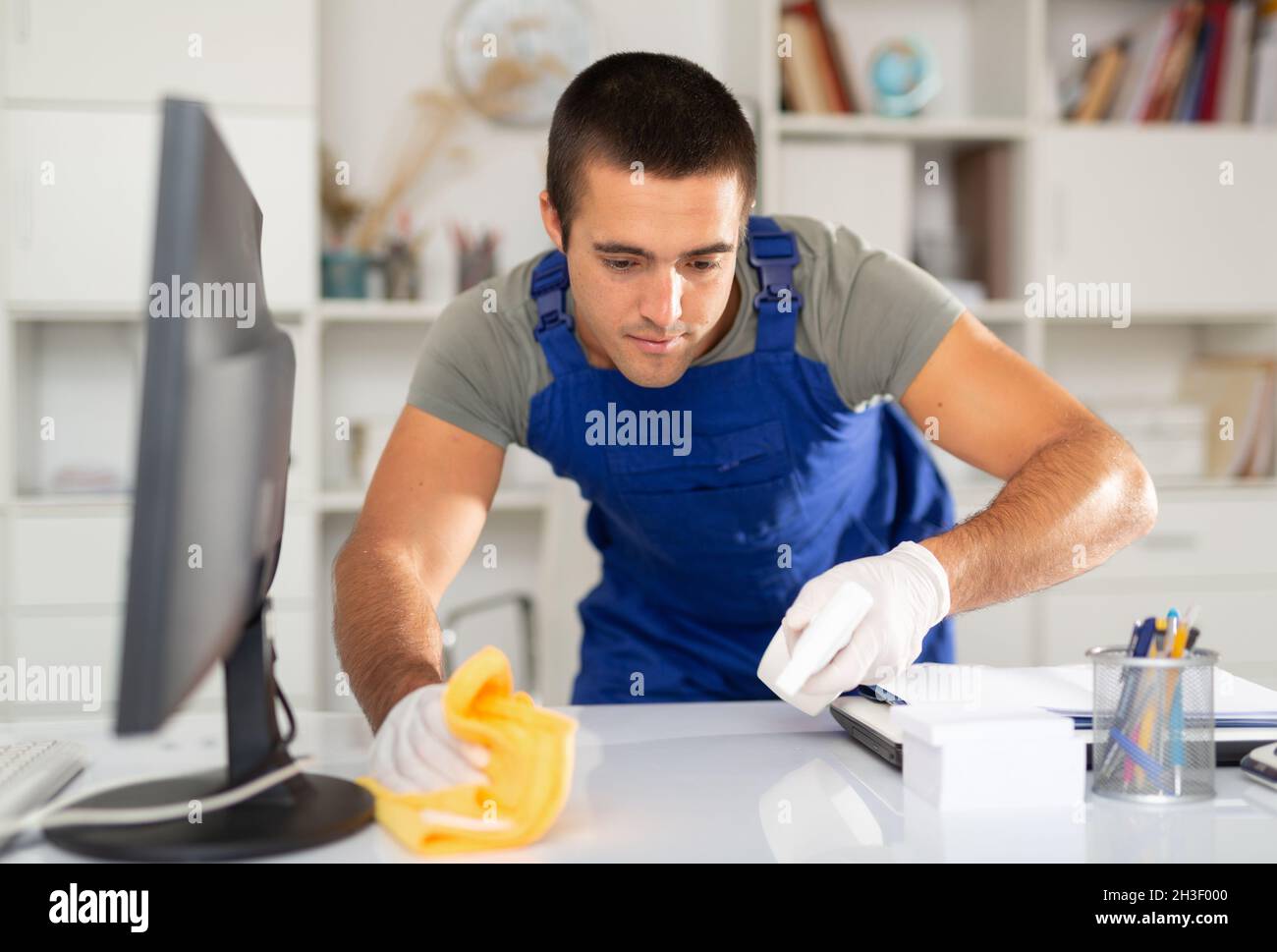 Cleaning worker wiping office desk with detergent Stock Photo - Alamy