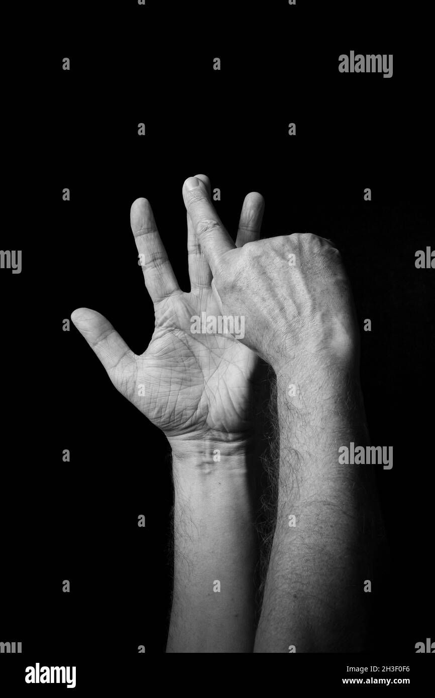 Dramatic B+W image of male hand fingerspelling BSL British sign ...