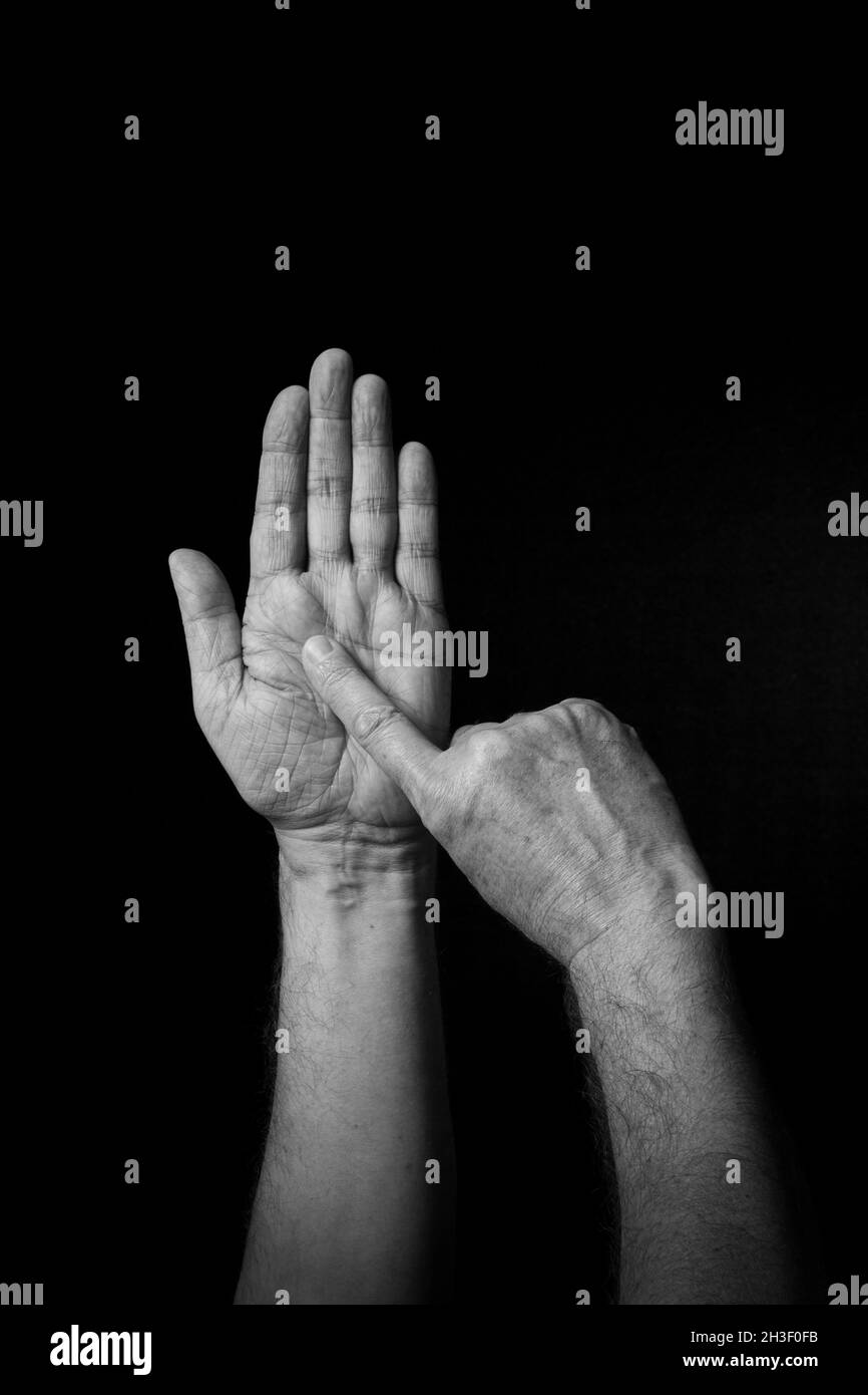 Dramatic B+W image of male hand fingerspelling BSL British sign ...