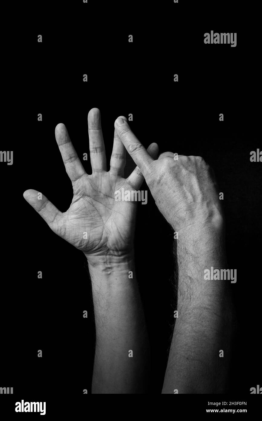 Dramatic B+W image of male hand fingerspelling BSL British sign ...