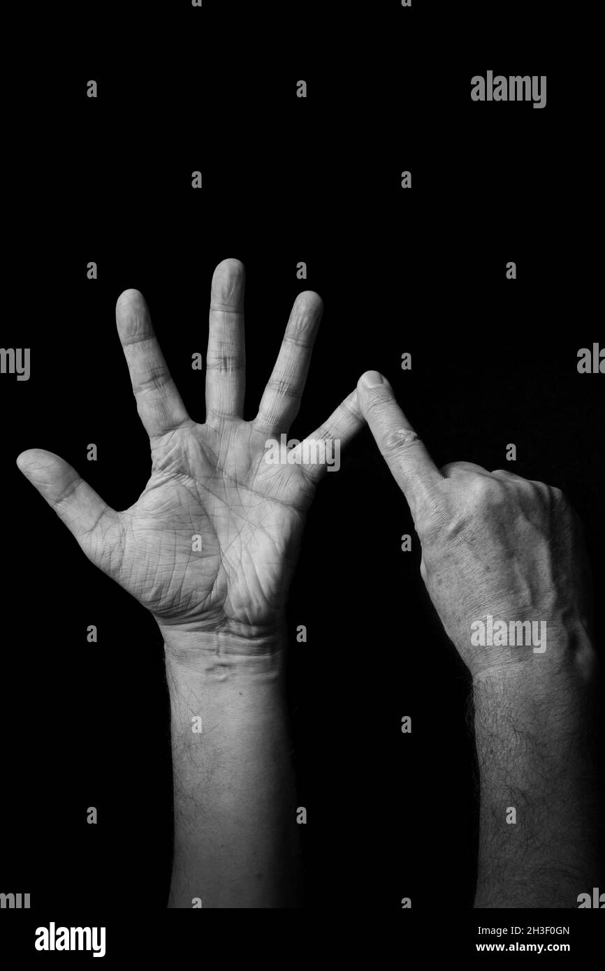 Dramatic B+W image of male hand fingerspelling BSL British sign ...