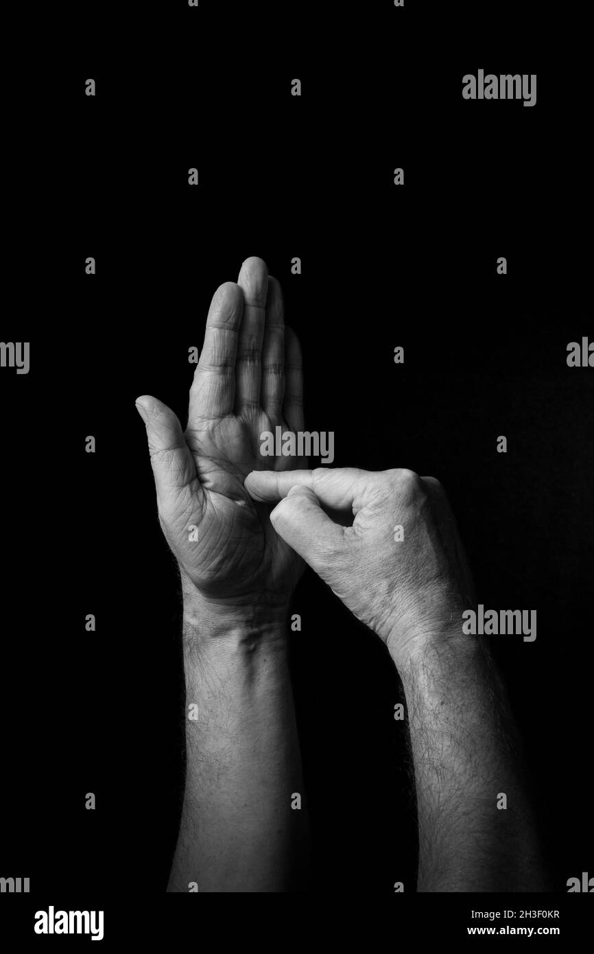 Dramatic B+W image of male hand fingerspelling BSL British sign ...