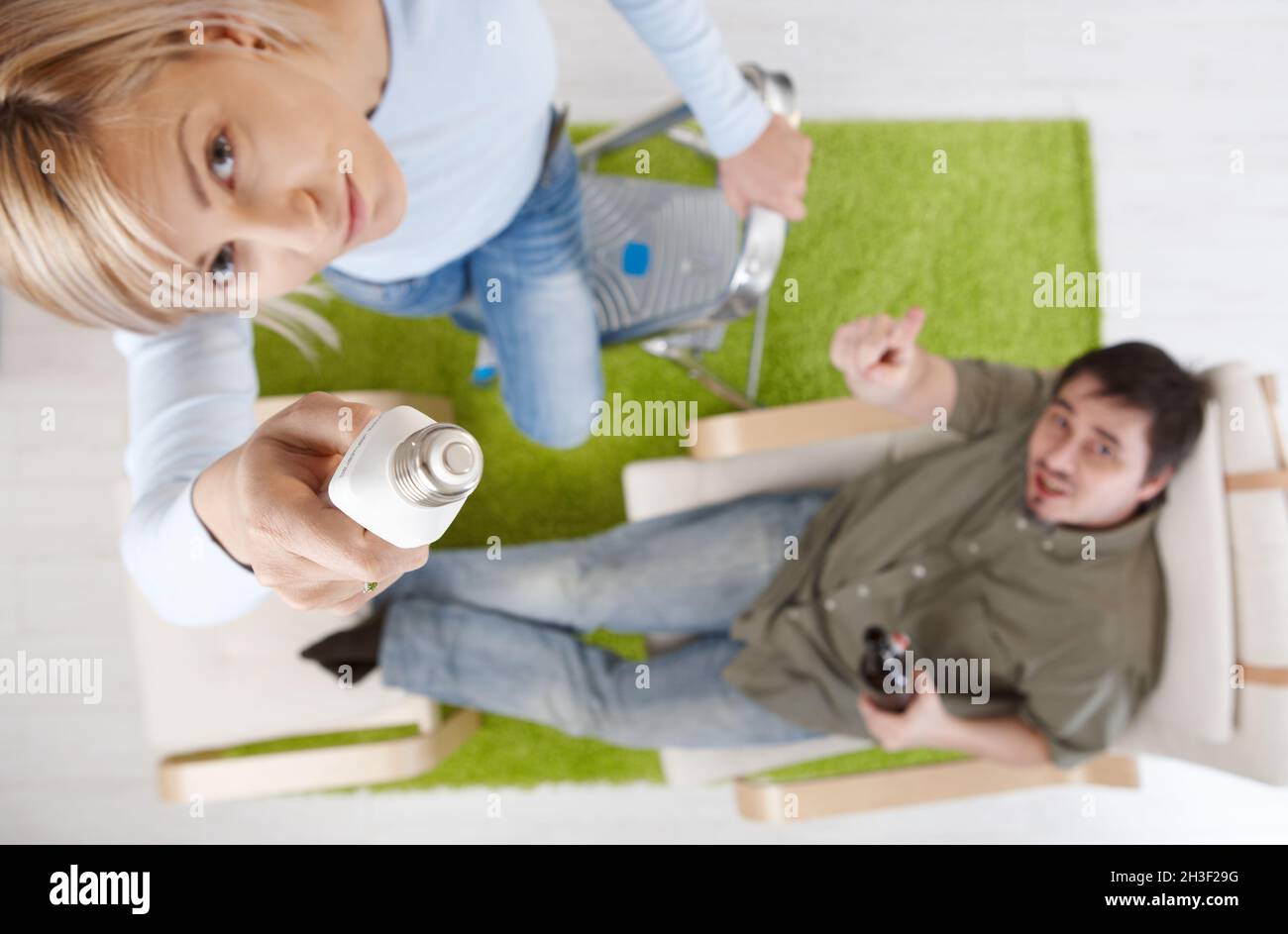 Woman changing light bulb Stock Photo - Alamy