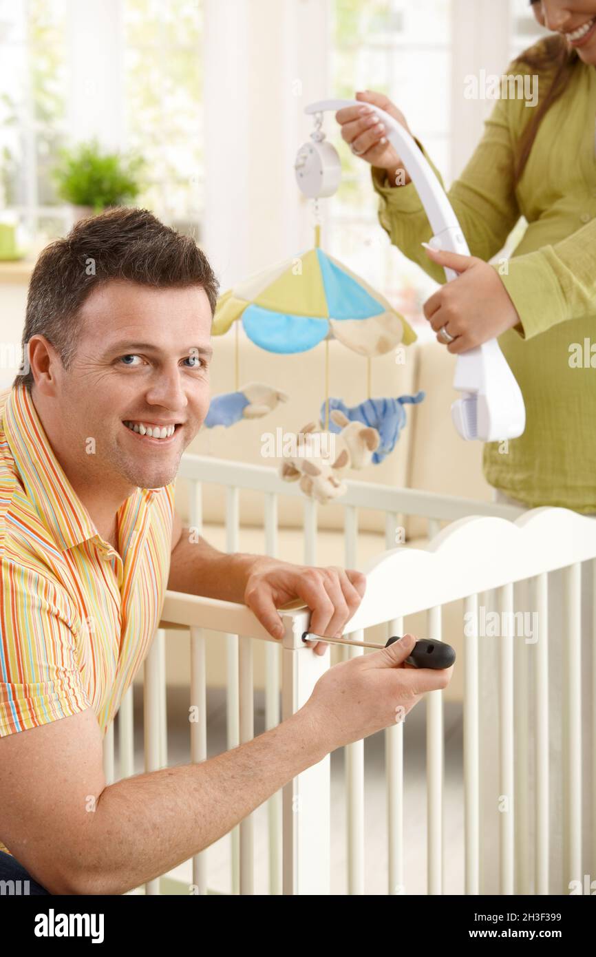 Portrait of man fixing baby bed Stock Photo - Alamy