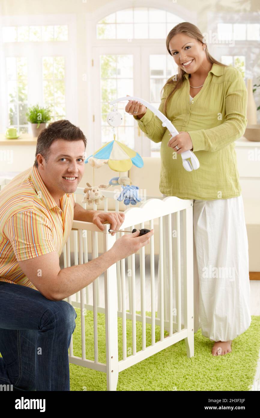 Portrait of couple fixing baby bed Stock Photo - Alamy