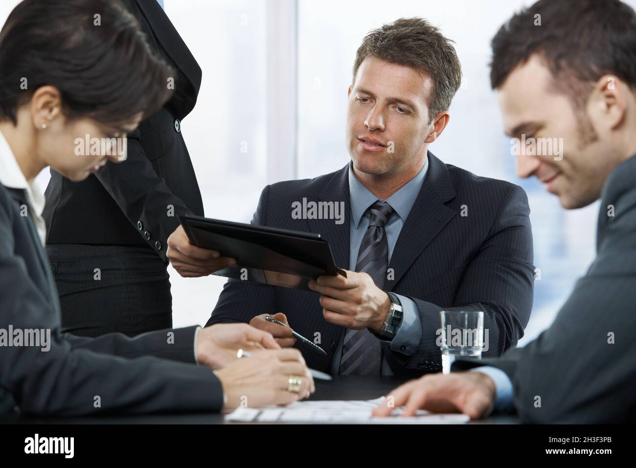Female secretary handing documents businesspeople hi-res stock ...