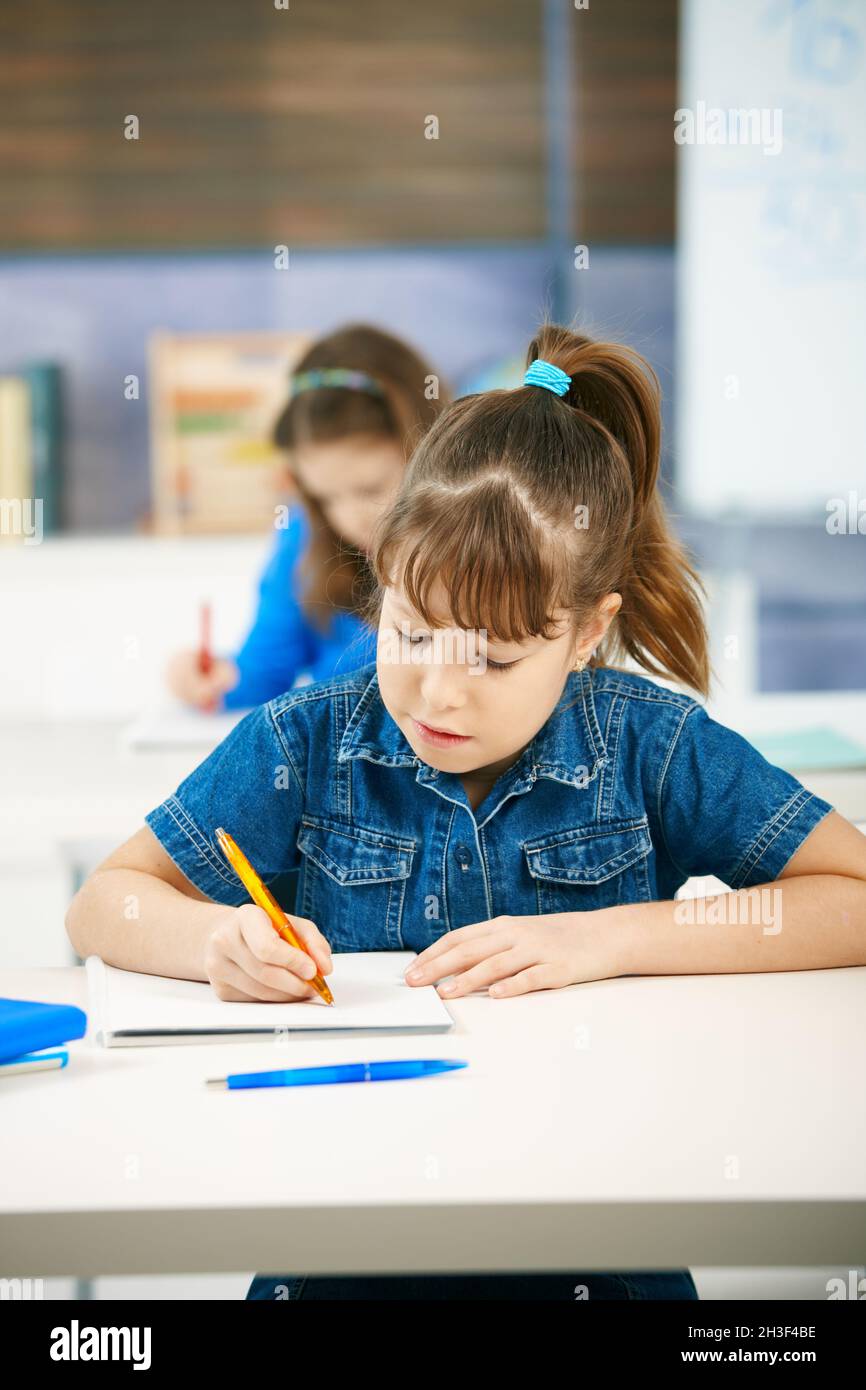 Young girl writing at school Stock Photo - Alamy