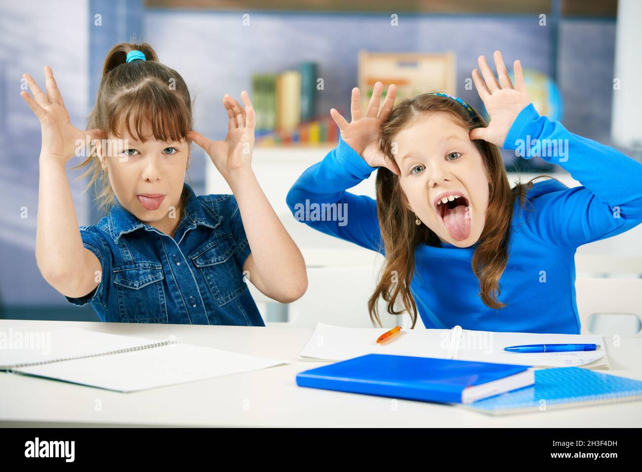 Children sticking tongue in classroom Stock Photo - Alamy