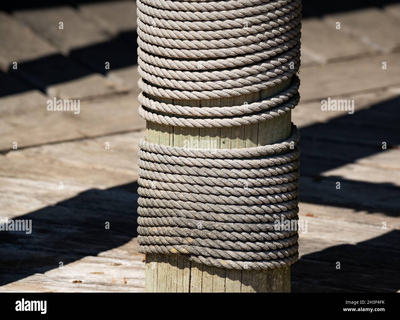 Wooden pole with a rope around it Stock Photo - Alamy