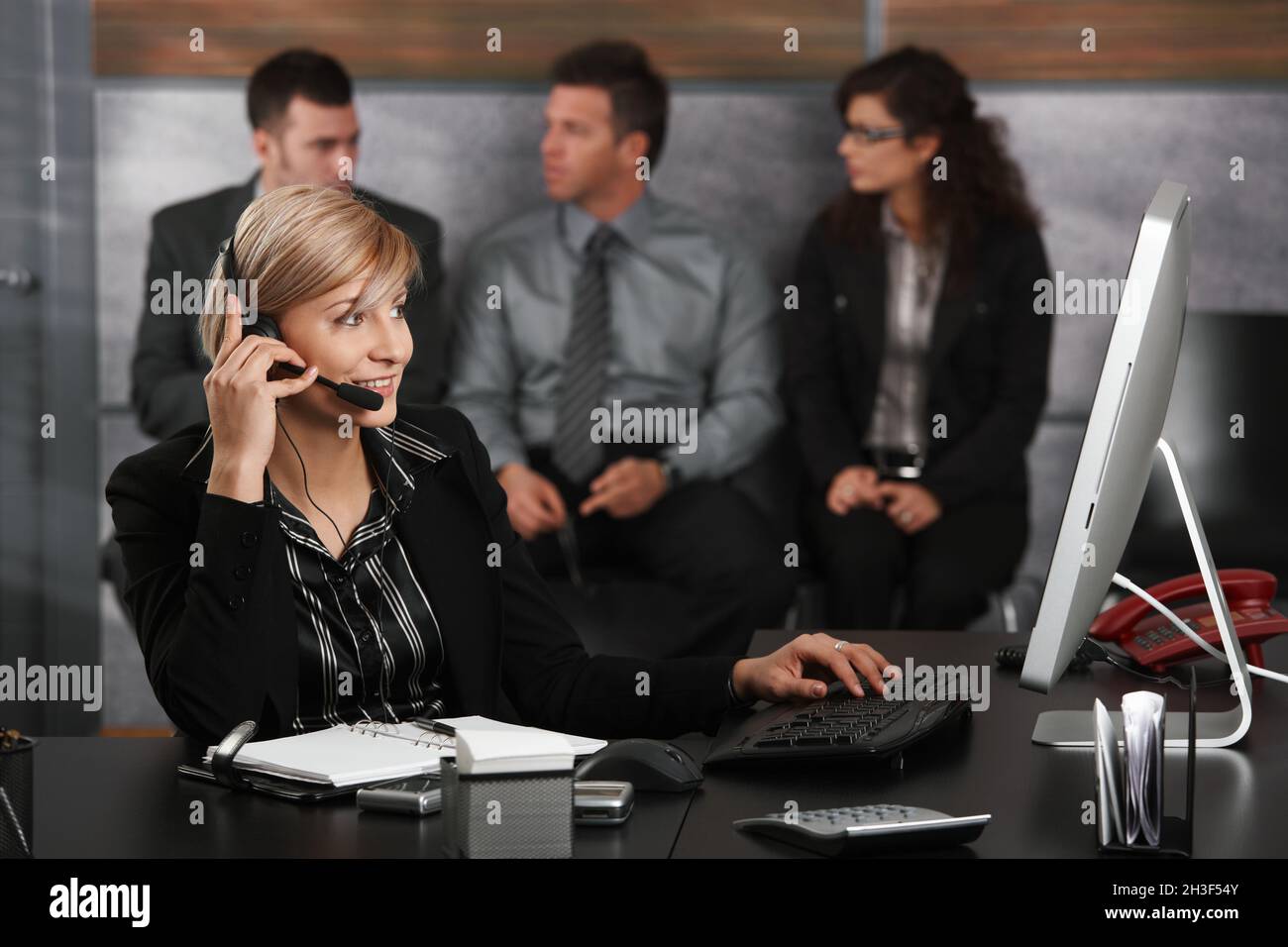 Receptionist talking on phone Stock Photo - Alamy