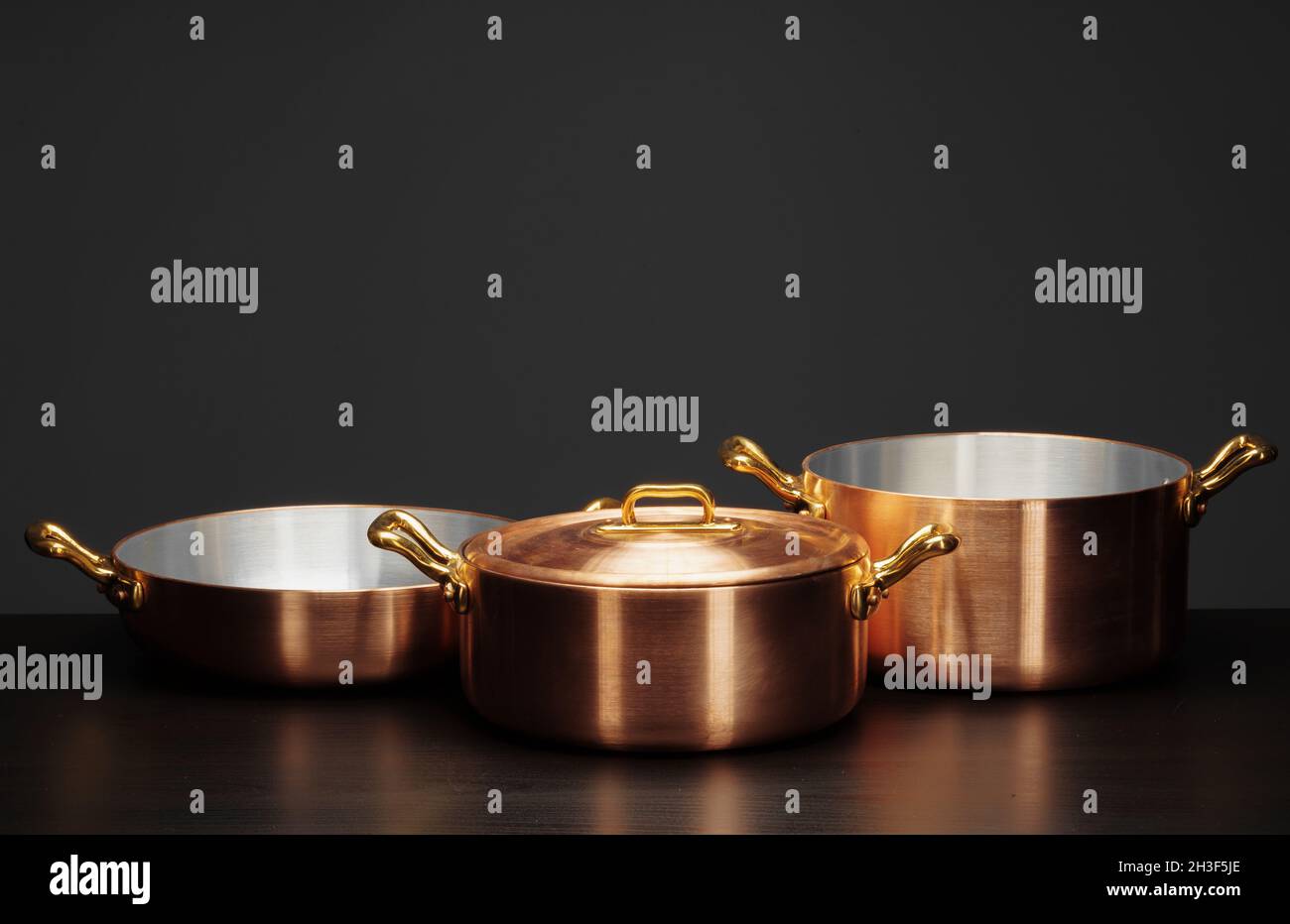 Shiny vintage copper cookware over dark background Stock Photo - Alamy