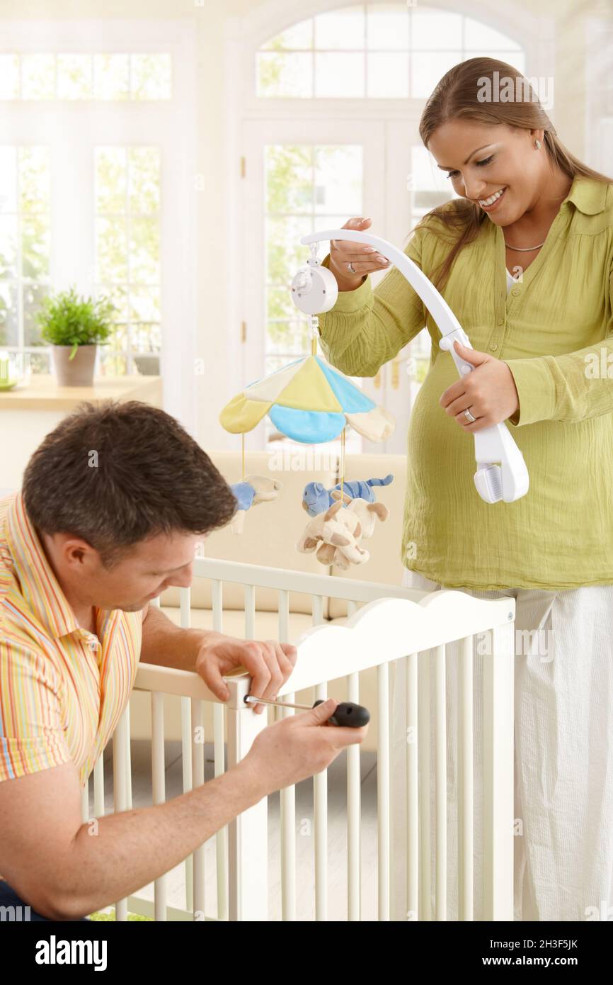 Couple fixing baby bed together Stock Photo - Alamy