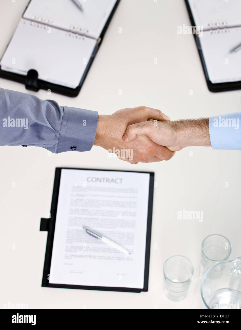 Handshake over meeting table Stock Photo - Alamy
