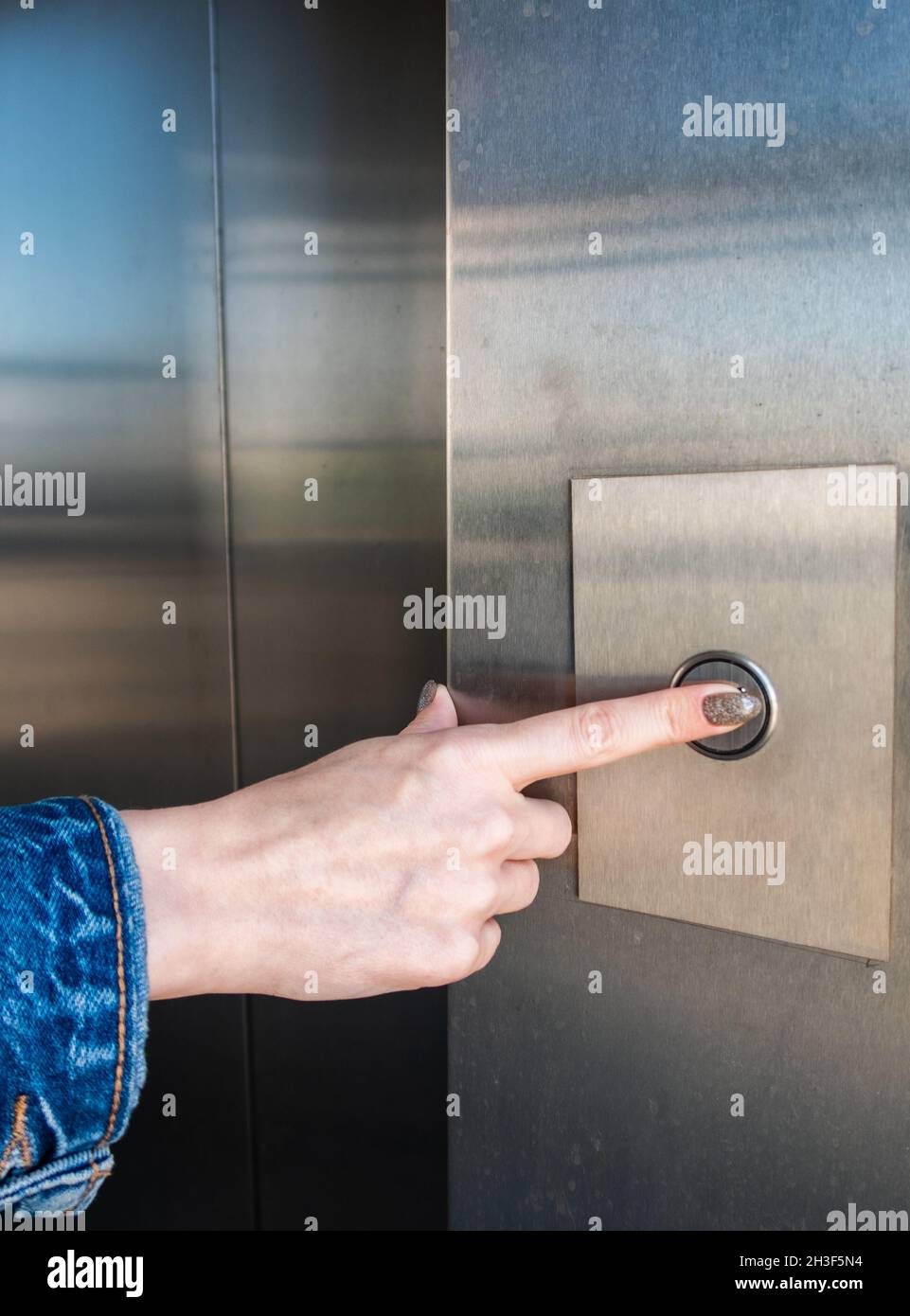Woman pressing button lift hi-res stock photography and images - Alamy