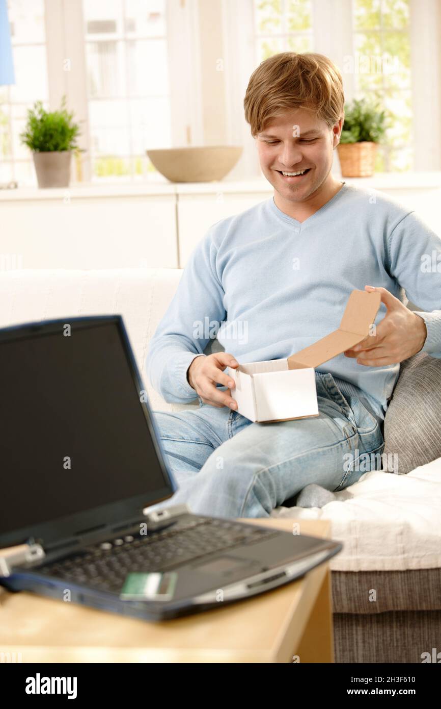 Young man opening box Stock Photo - Alamy