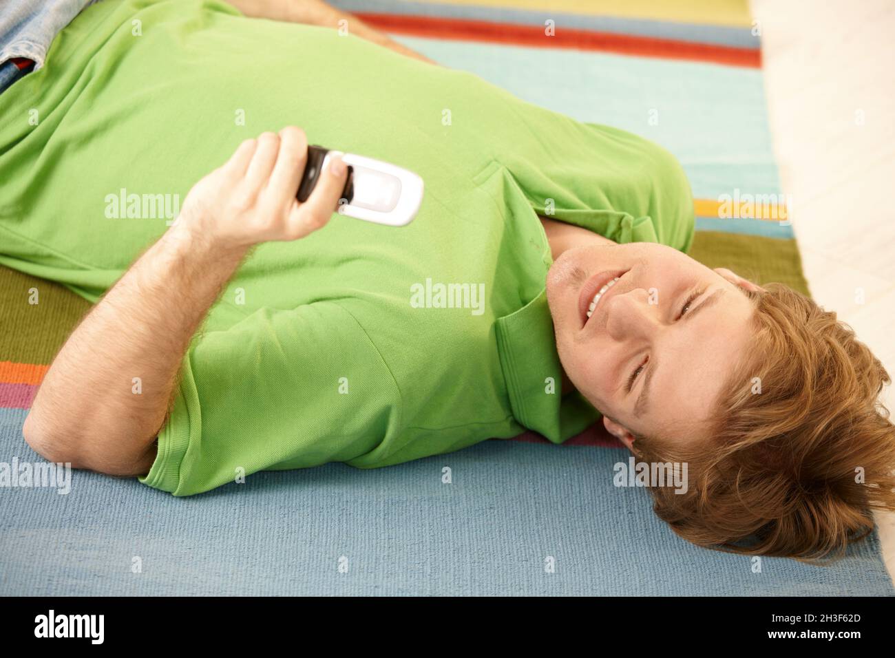 Guy with cellphone on floor Stock Photo - Alamy