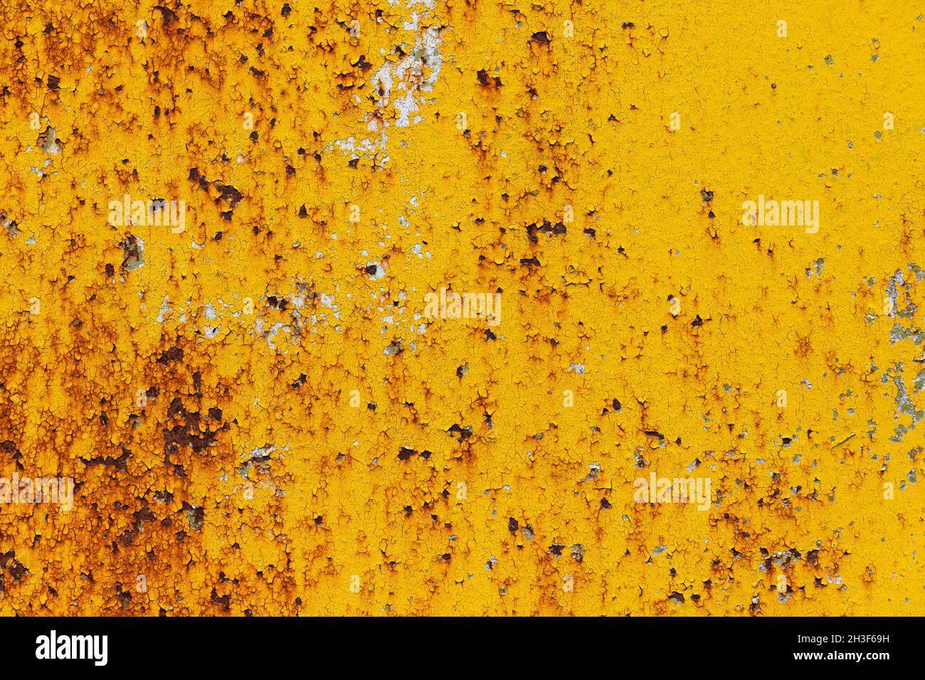 Old yellow grungy metal wall with peeling paint and rusty spots ...