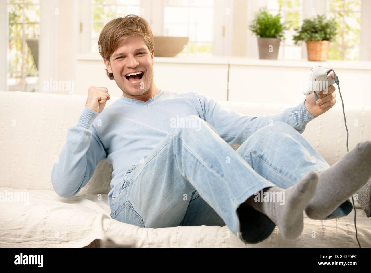 Laughing guy with computer game Stock Photo - Alamy