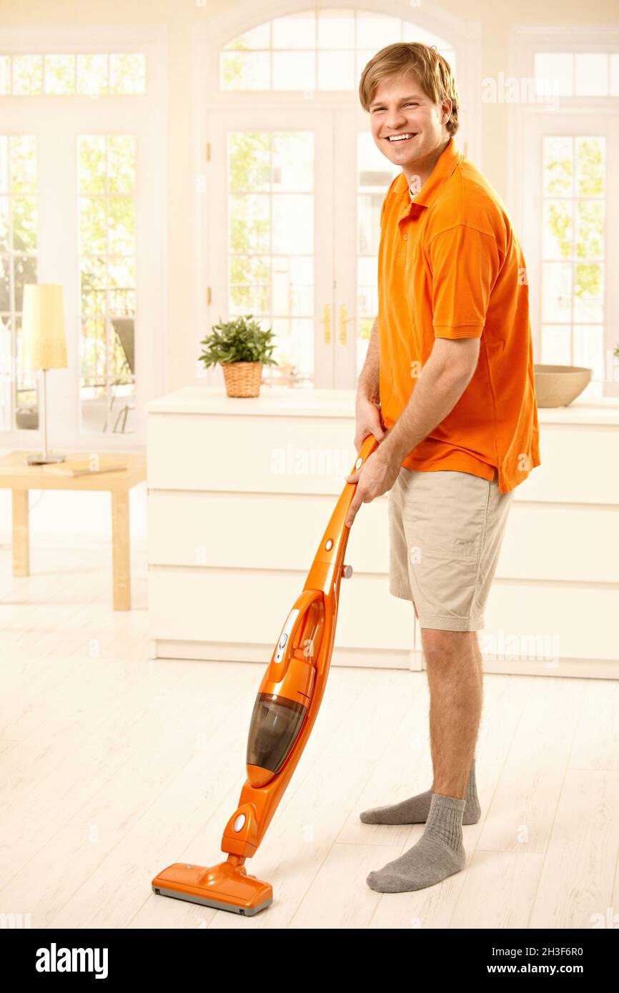 Happy guy with hoover Stock Photo - Alamy