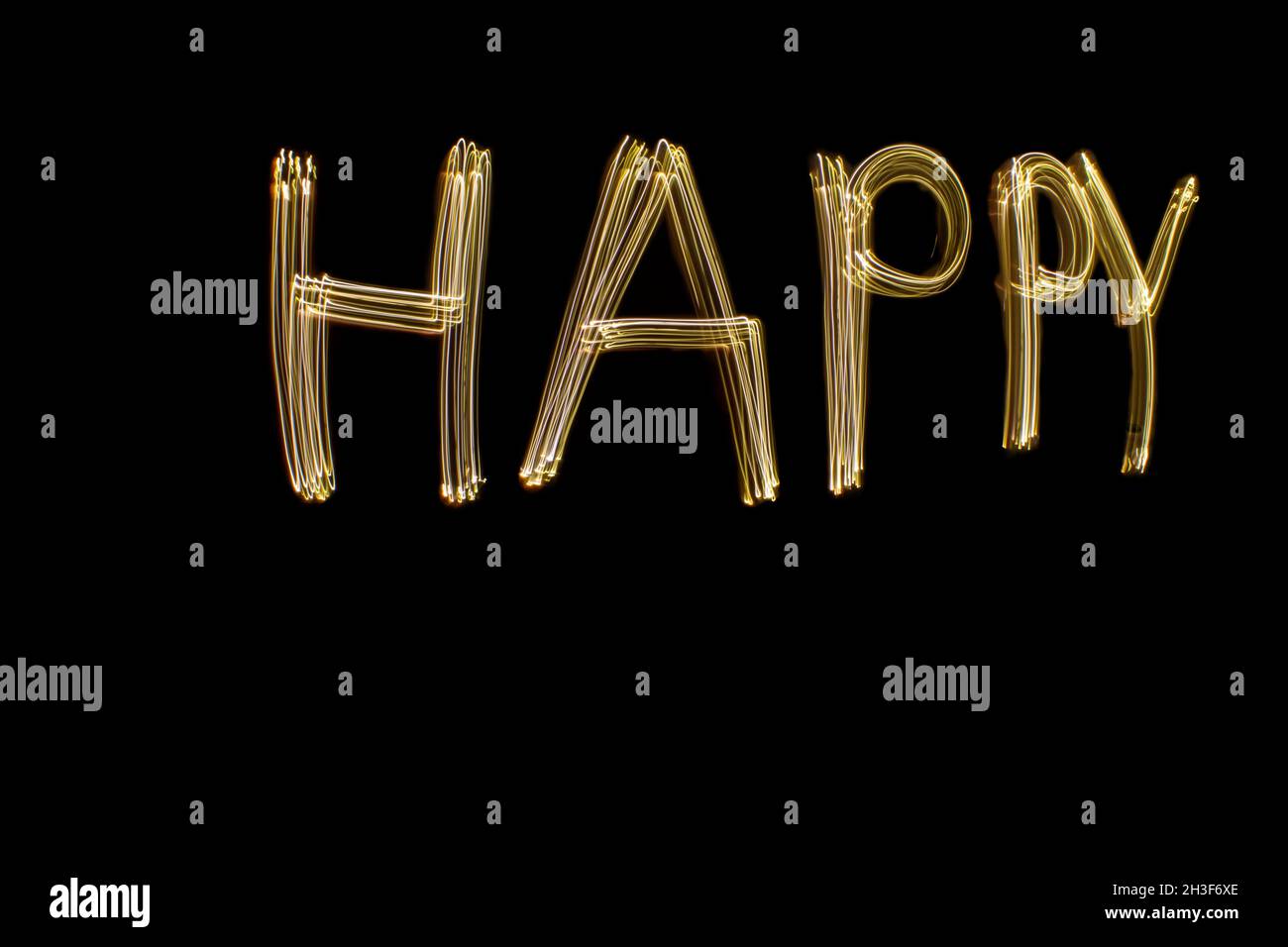 The word 'happy' written against black background with long exposure ...