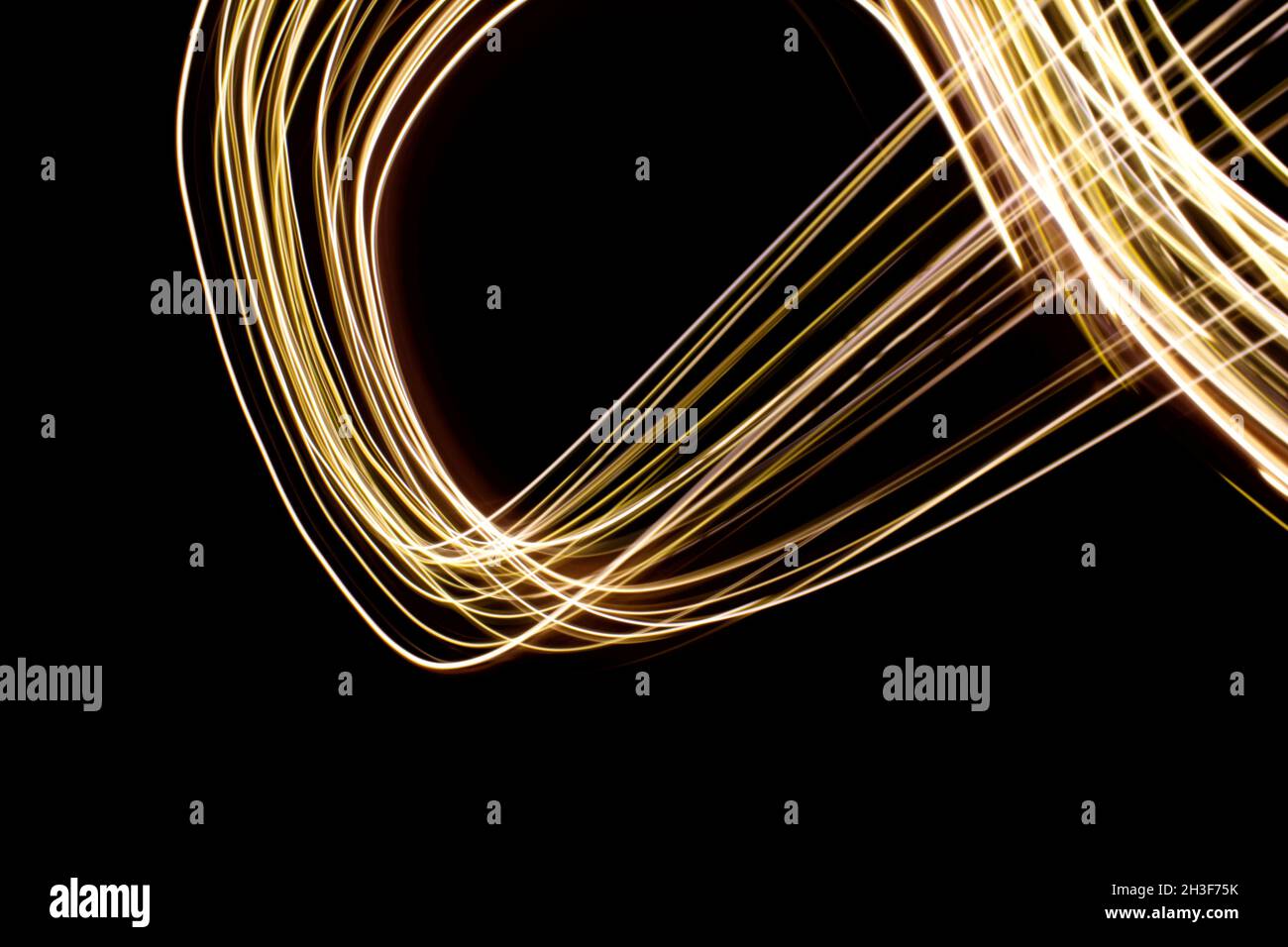 Light painting golden swirl. Neon yellow color abstract swirl against ...